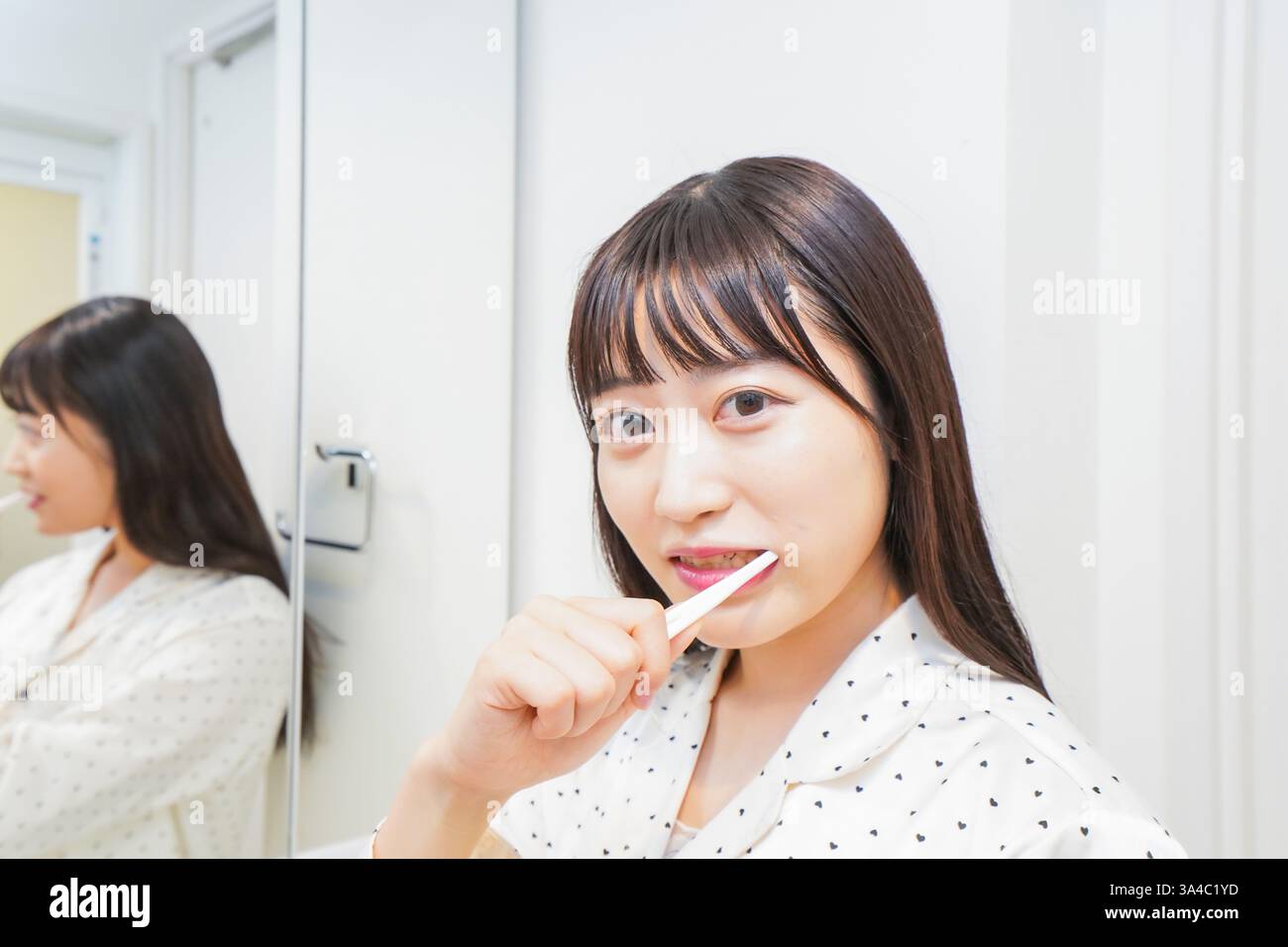 Young woman brushing her teeth before bed Stock Photo - Alamy