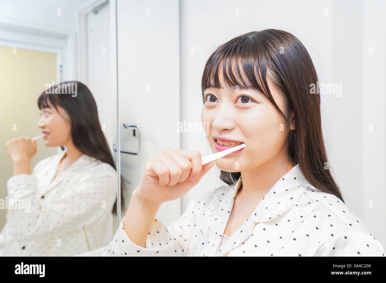 Young woman brushing her teeth before bed Stock Photo - Alamy