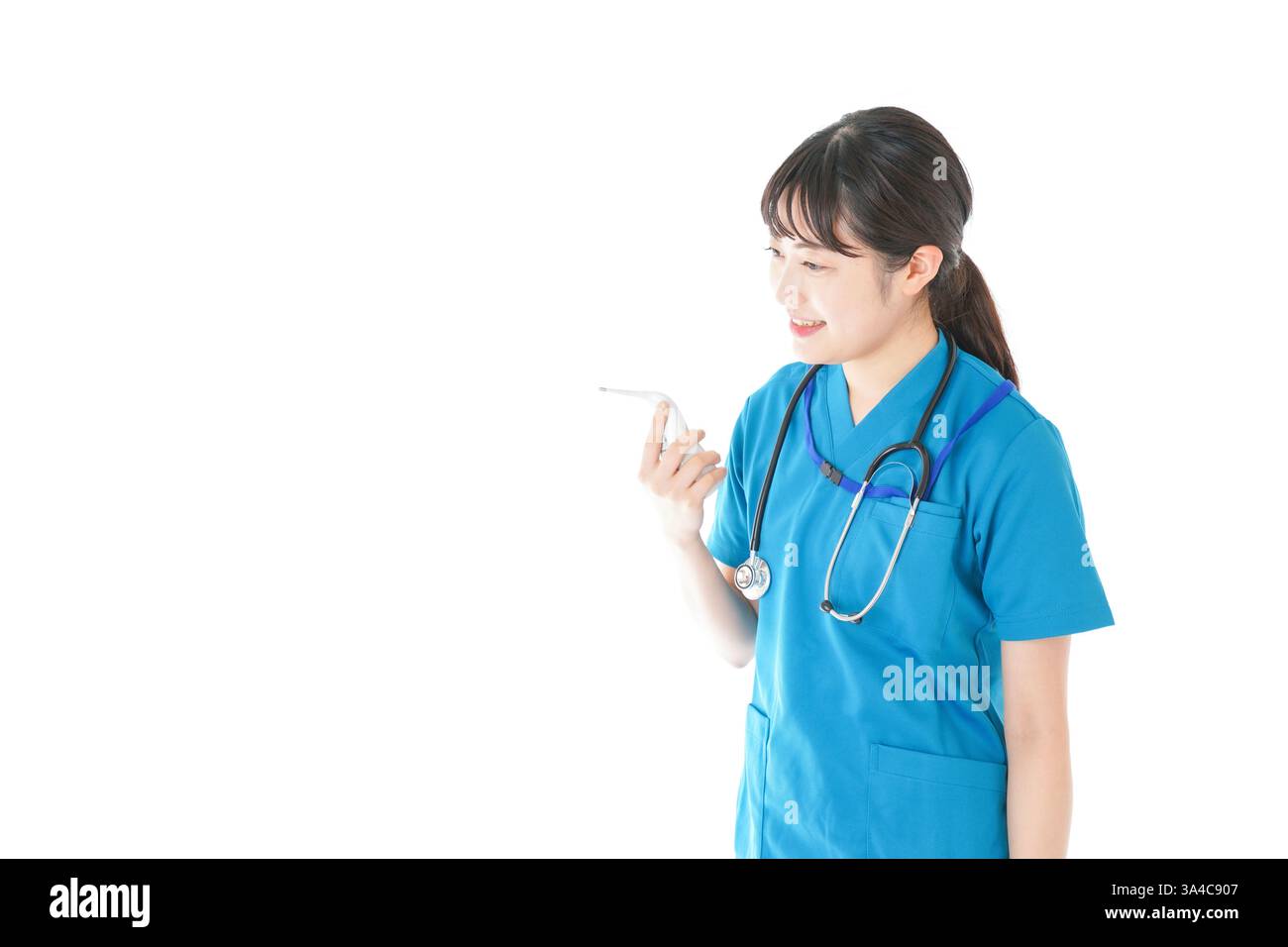 Smiling young nurse taking body temperature Stock Photo - Alamy