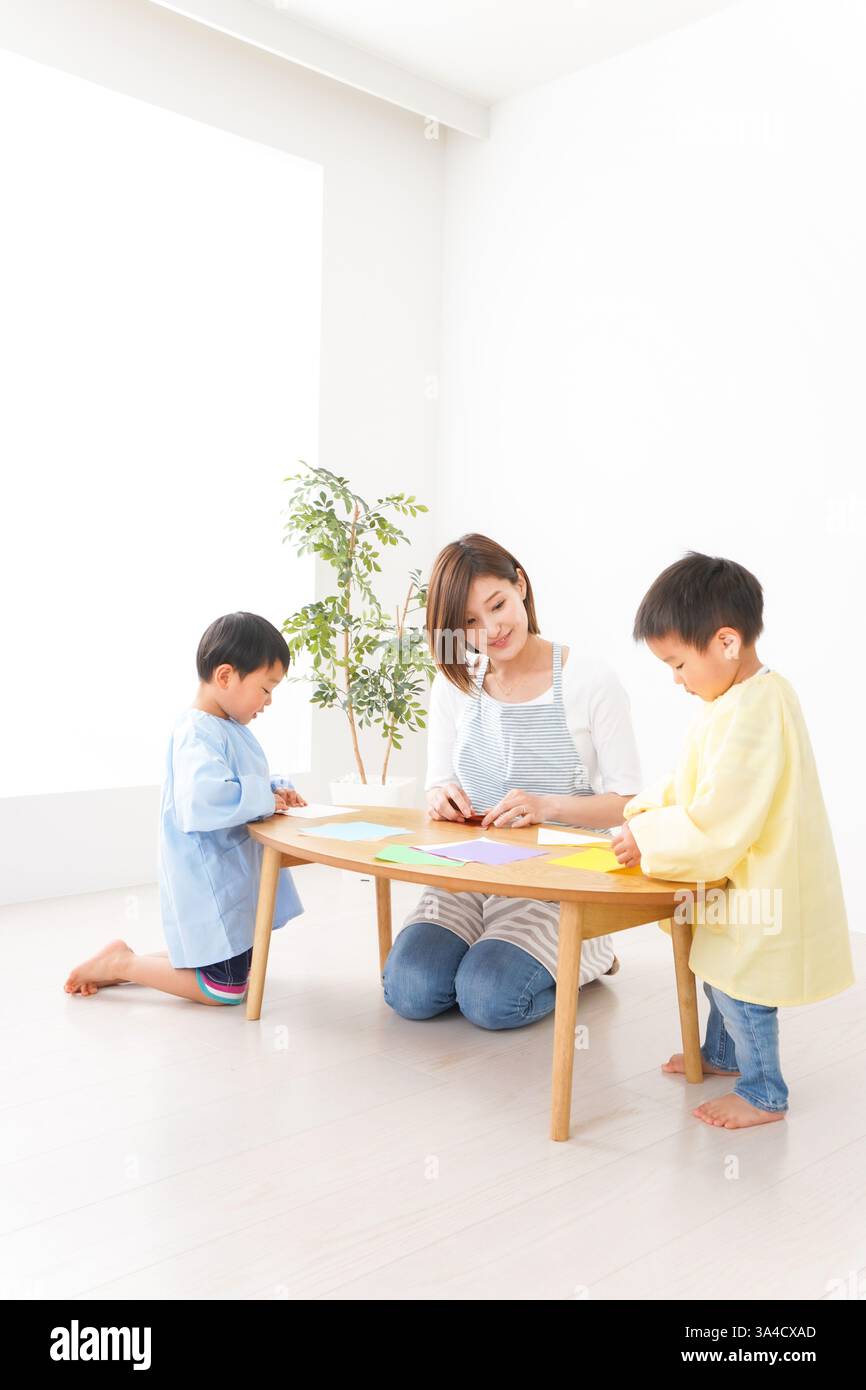 Children and teacher doing origami at the kindergarten Stock Photo - Alamy