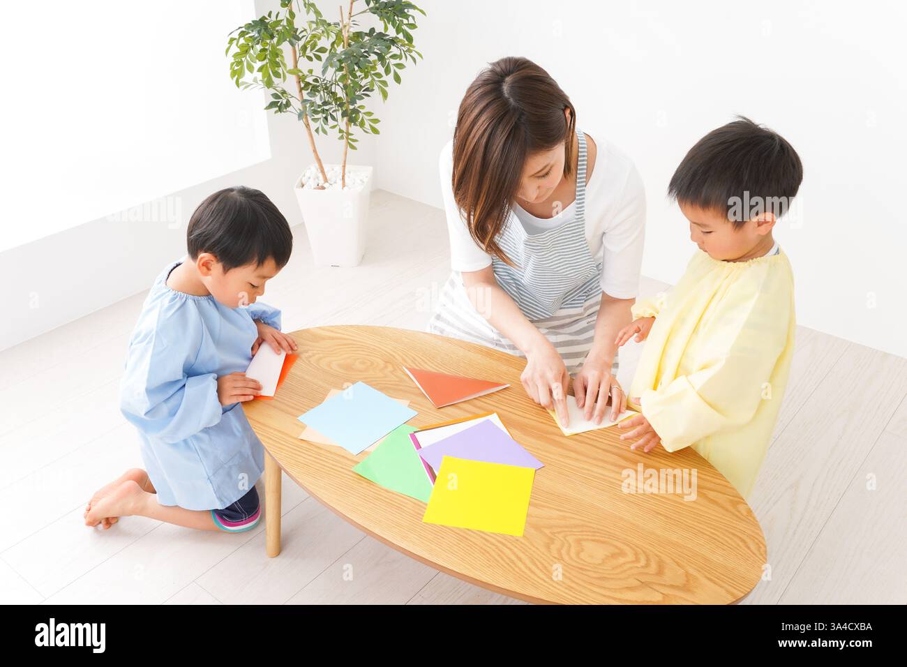 Children and teacher doing origami at the kindergarten Stock Photo - Alamy