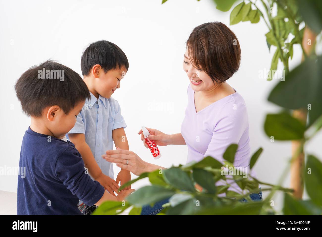 A mother sprays her child with disinfectant spray Stock Photo - Alamy