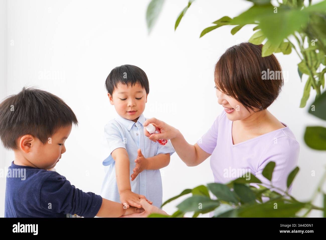 A mother sprays her child with disinfectant spray Stock Photo - Alamy