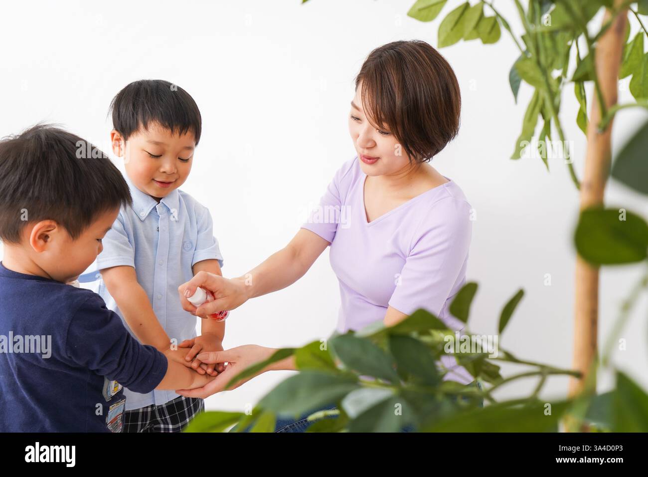 A mother sprays her child with disinfectant spray Stock Photo - Alamy