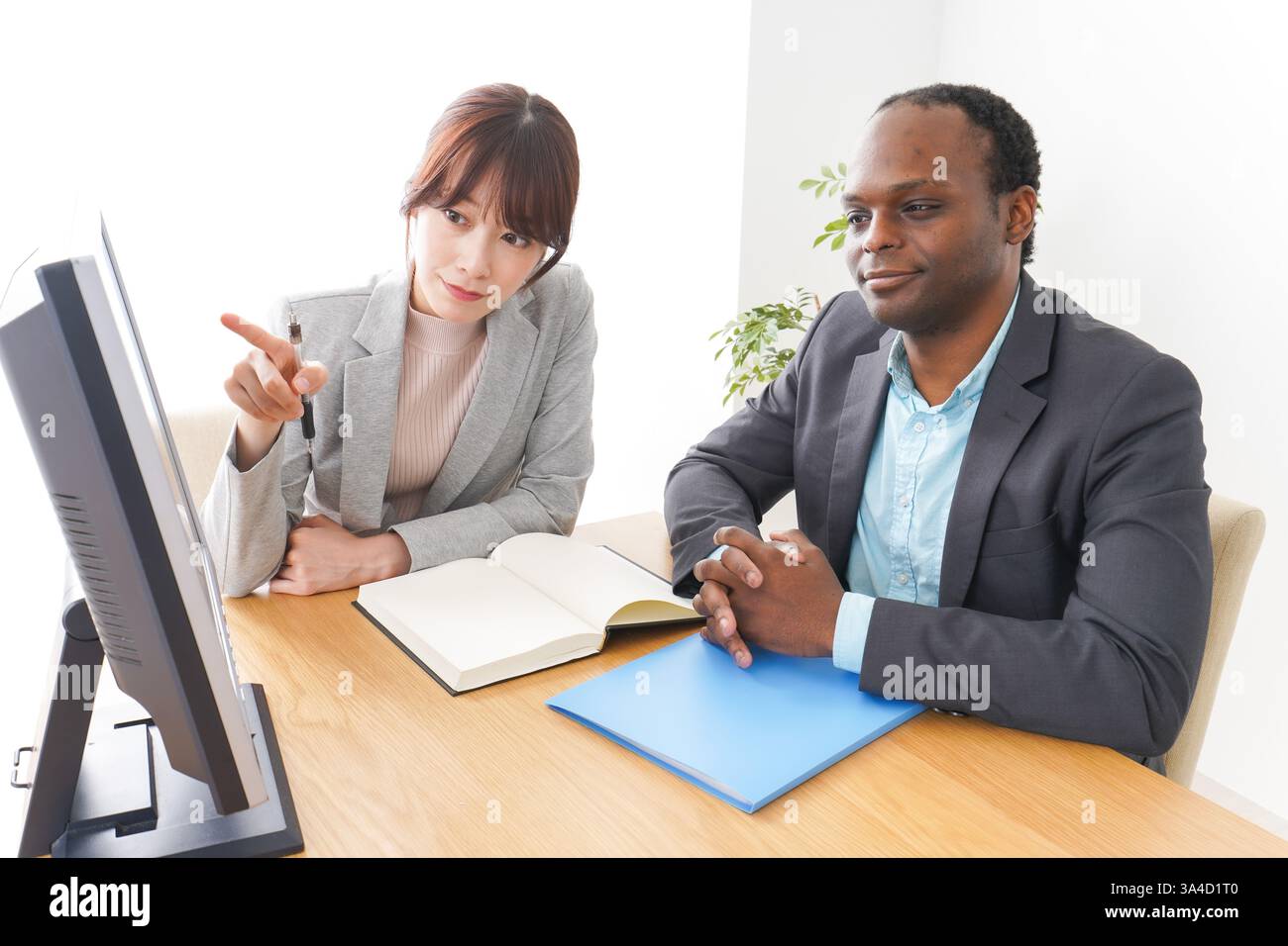 Two business people using a computer in an office Stock Photo - Alamy