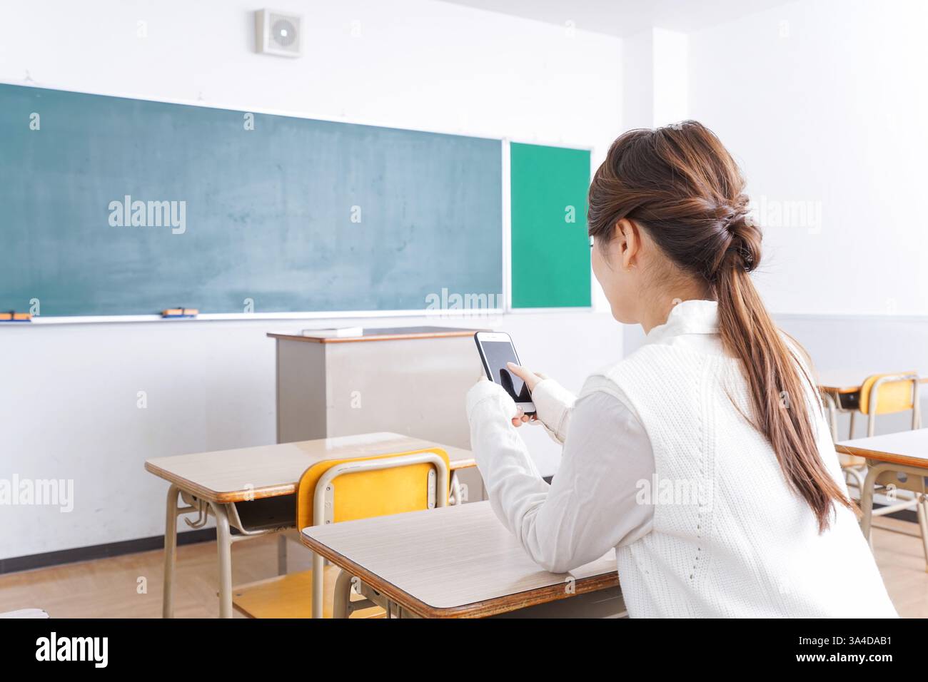 Student using mobile phone in classroom Stock Photo - Alamy