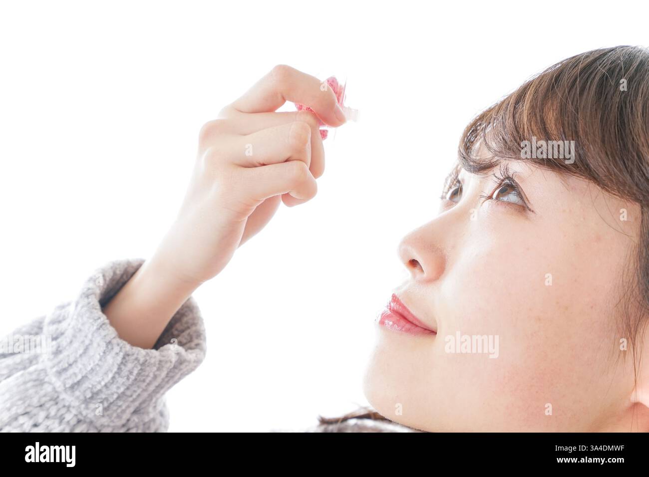Woman applying eye drops Stock Photo - Alamy