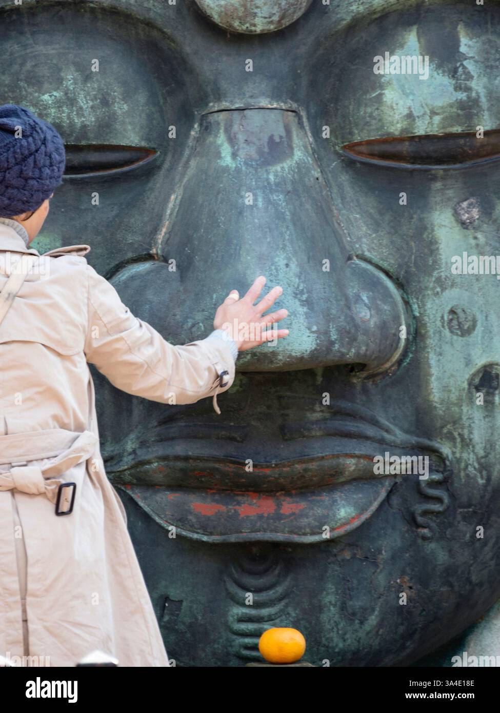 Visitors touch the "Crying" Daibutsu *Great Buddha, which is located in ...