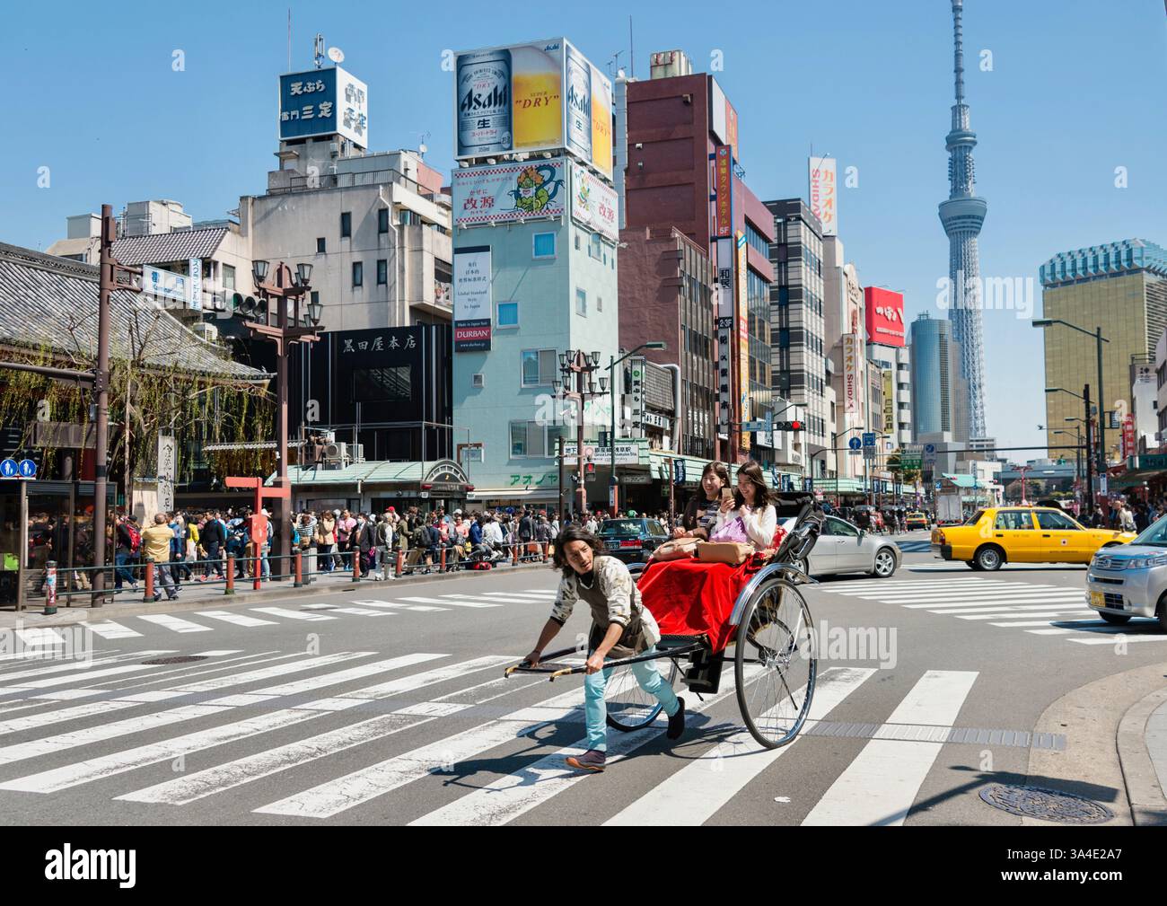 Tokyo Sky Tree in the distance, a Jin-Rikisha driver passes the ...