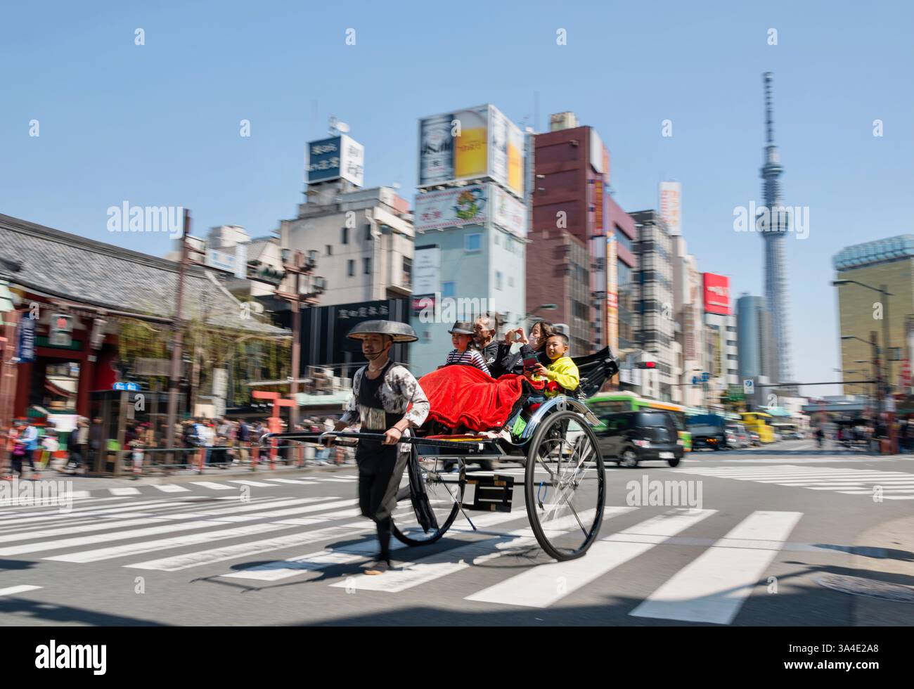 Tokyo Sky Tree in the distance, a Jin-Rikisha driver passes the ...