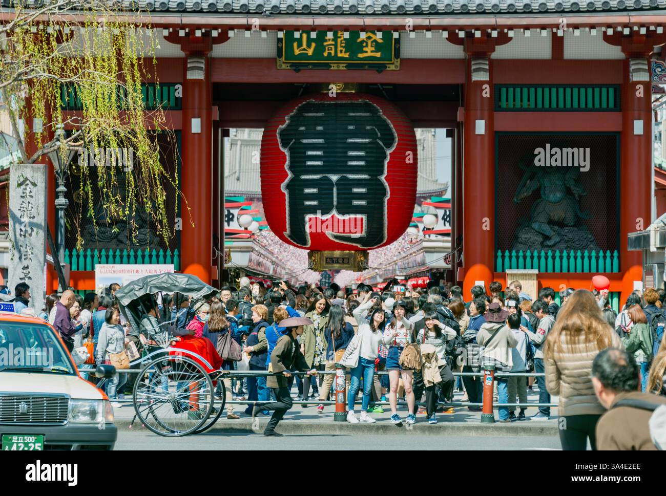 Jin-Rikisha pass by the giant lantern hanging at the Kaminarimon gate ...