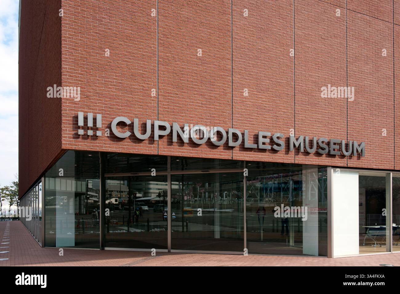 View of main entrance with sign and brick veneer façade of Nissin Cup ...