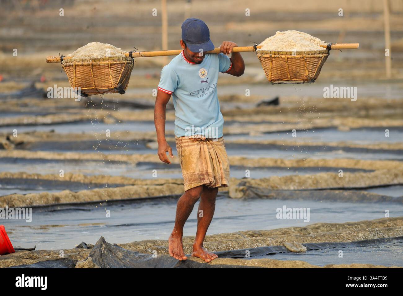 Barefoot in the salt beds, laborers, including children, work ...