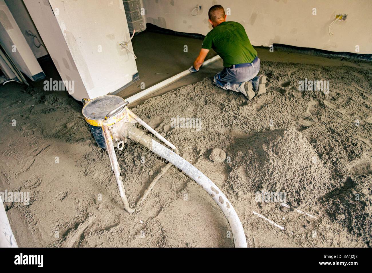 Pump machine throws out semi-dry floor screed mixture. Construction ...