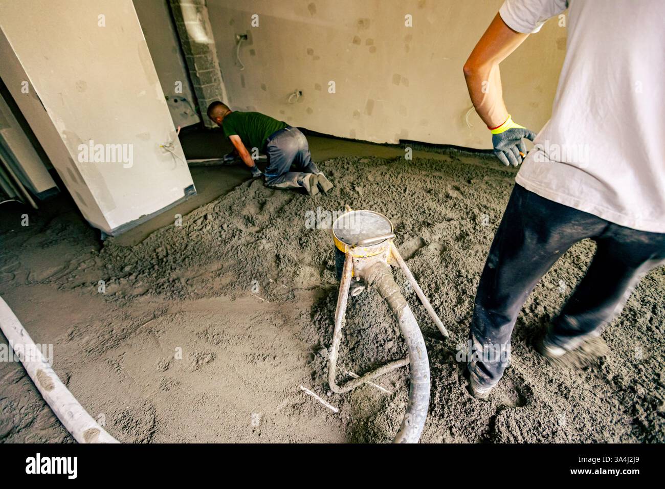 Pump machine throws out semi-dry floor screed mixture. Construction ...