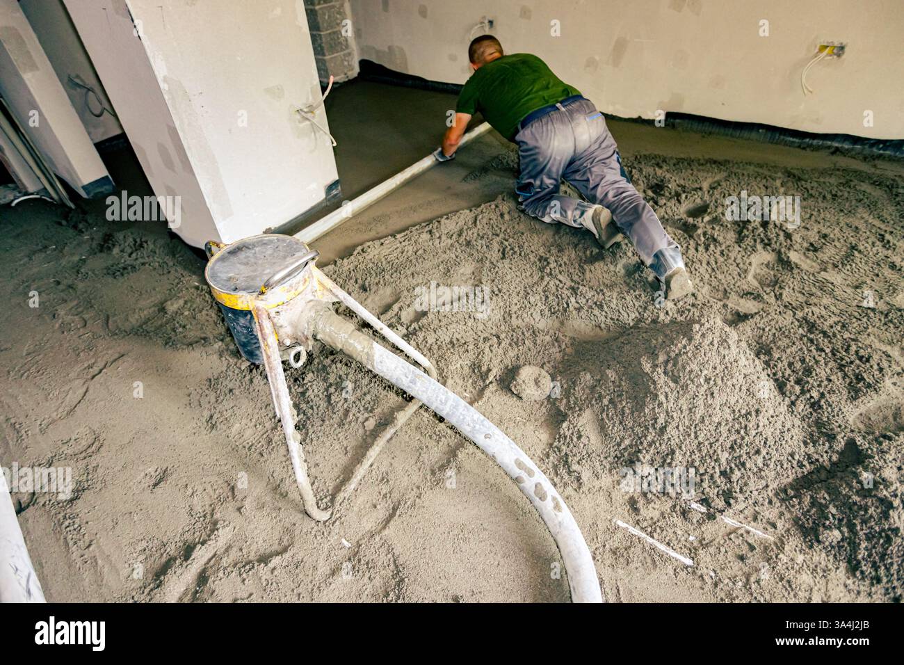 Pump machine throws out semi-dry floor screed mixture. Construction ...