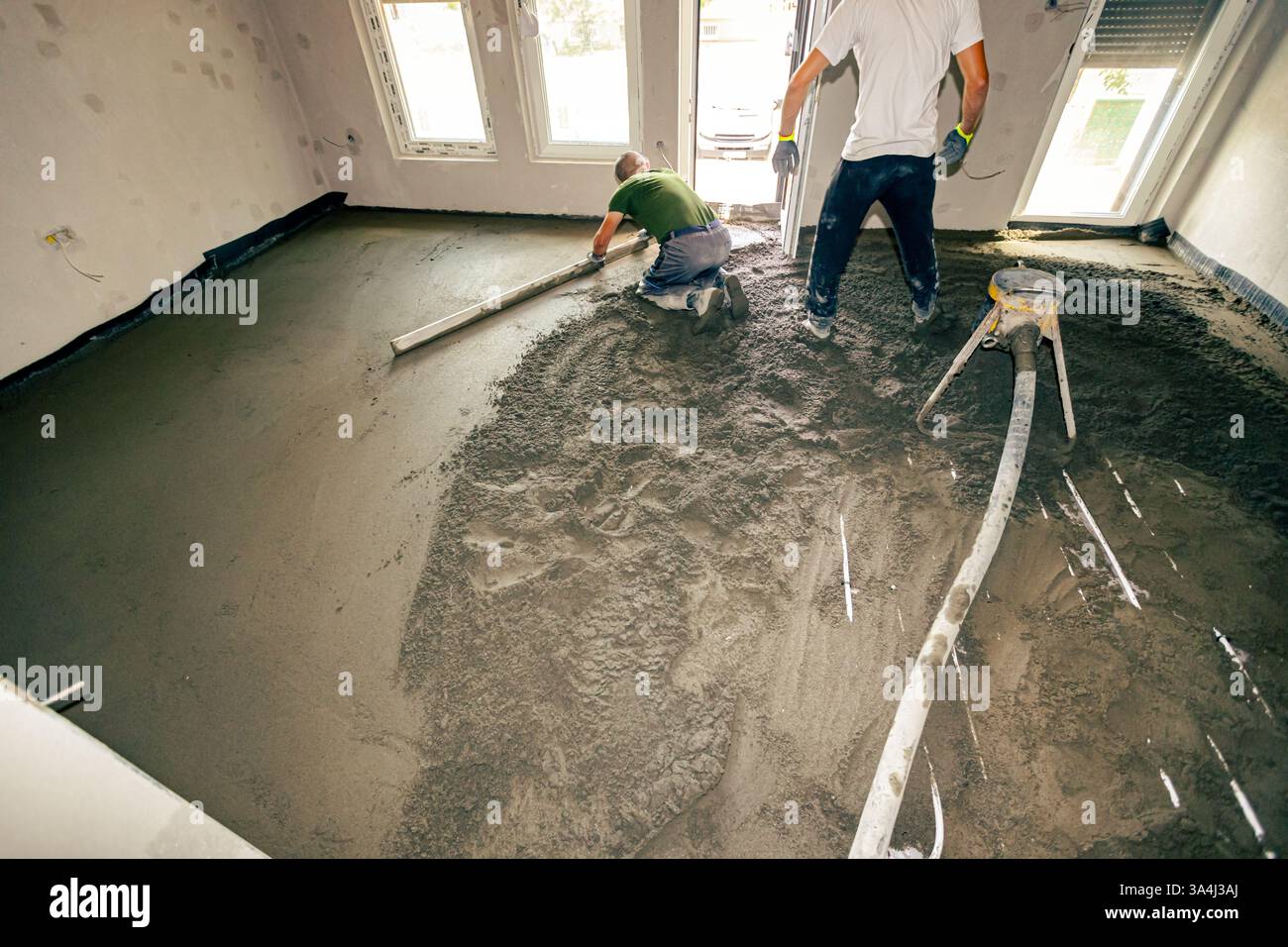 Pump machine throws out semi-dry floor screed mixture. Construction ...