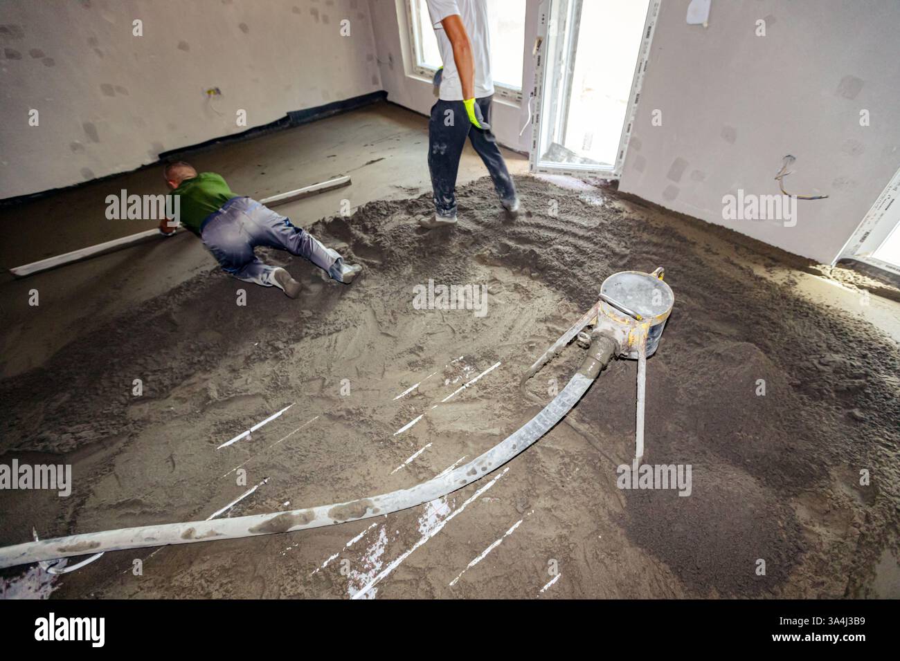 Pump machine throws out semi-dry floor screed mixture. Construction ...