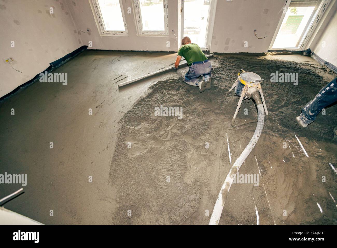 Pump machine throws out semi-dry floor screed mixture. Construction ...