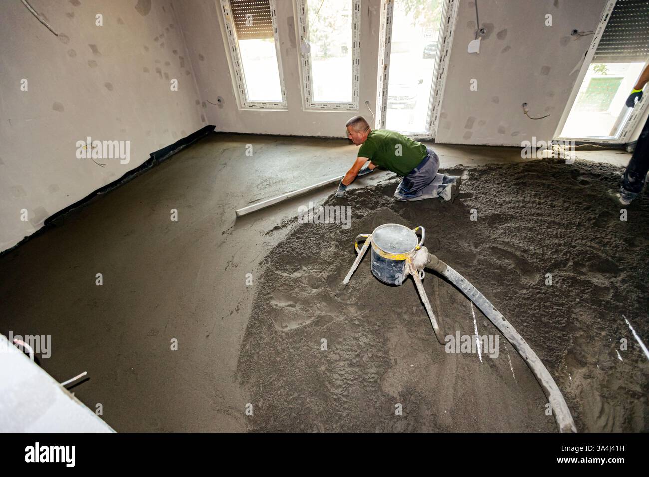 Pump machine throws out semi-dry floor screed mixture. Construction ...