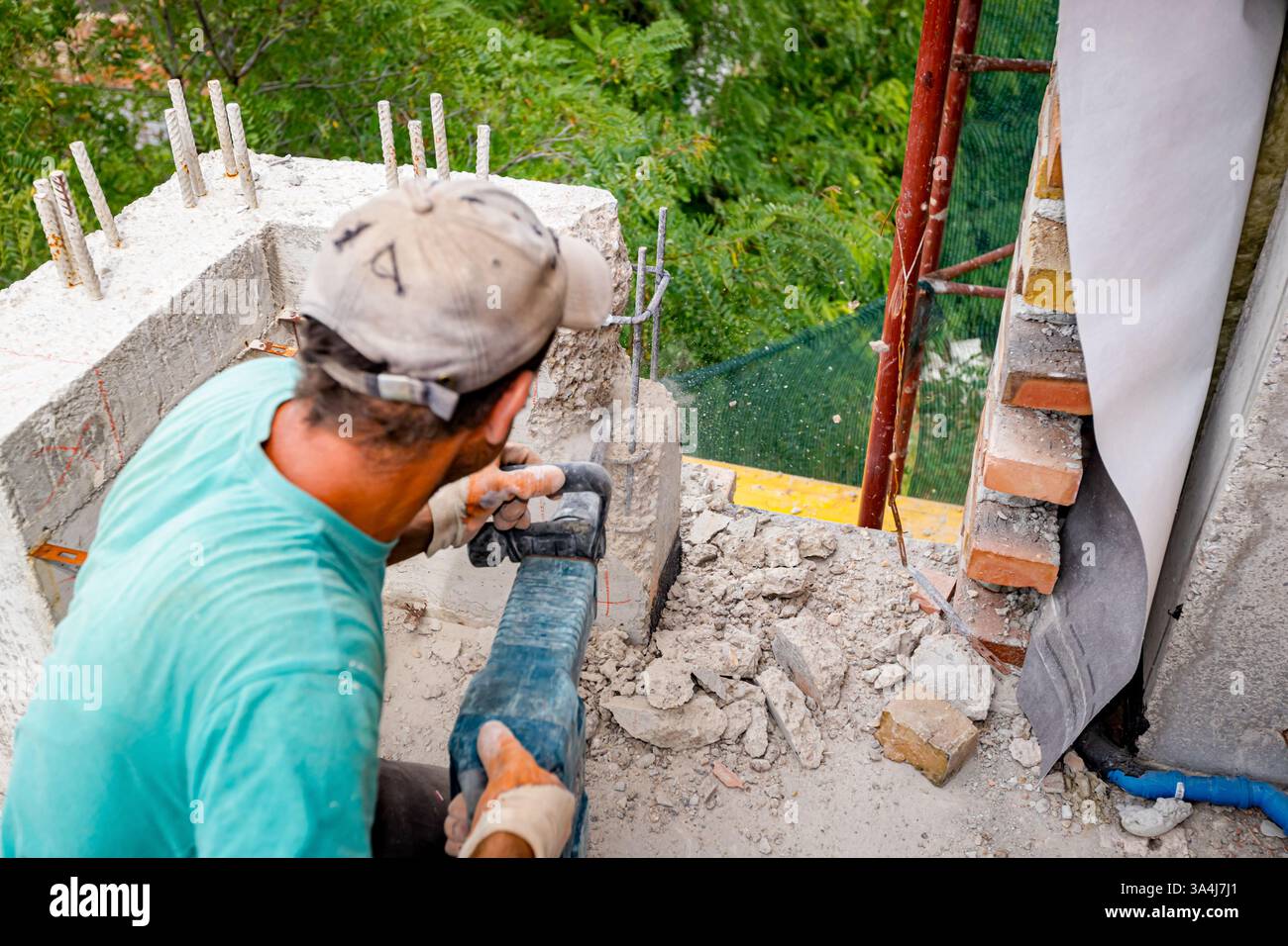 Building worker is using electric jackhammer to realign reinforced ...