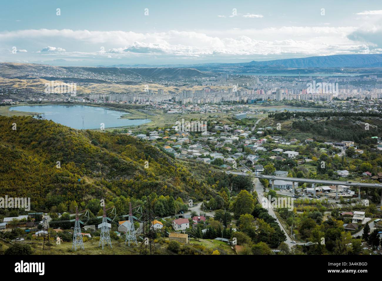 Panoramic view of a hillside city with green landscapes, houses, and ...