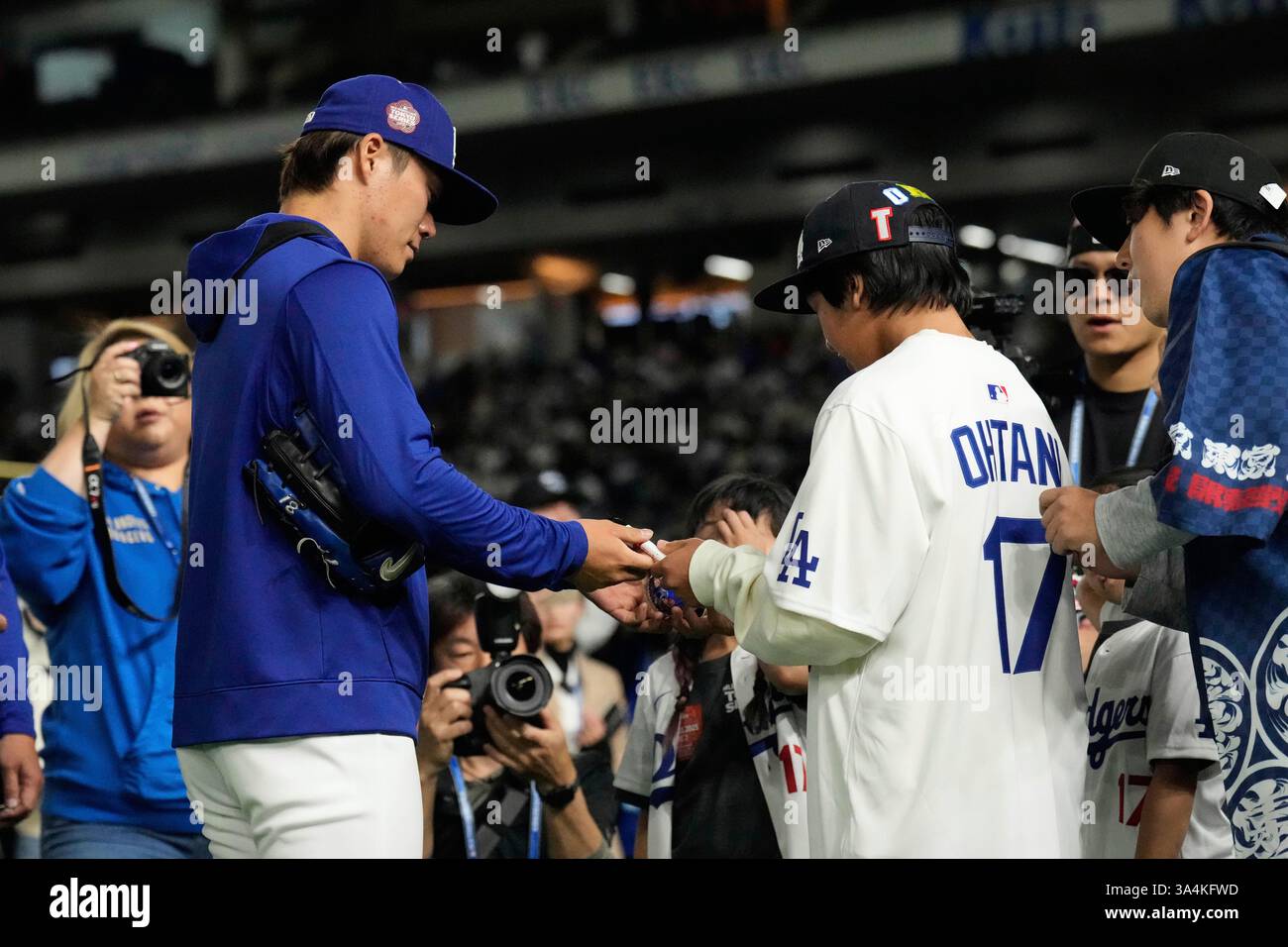 Los Angeles Dodgers' Yoshinobu Yamamoto, left, signs autographs for ...
