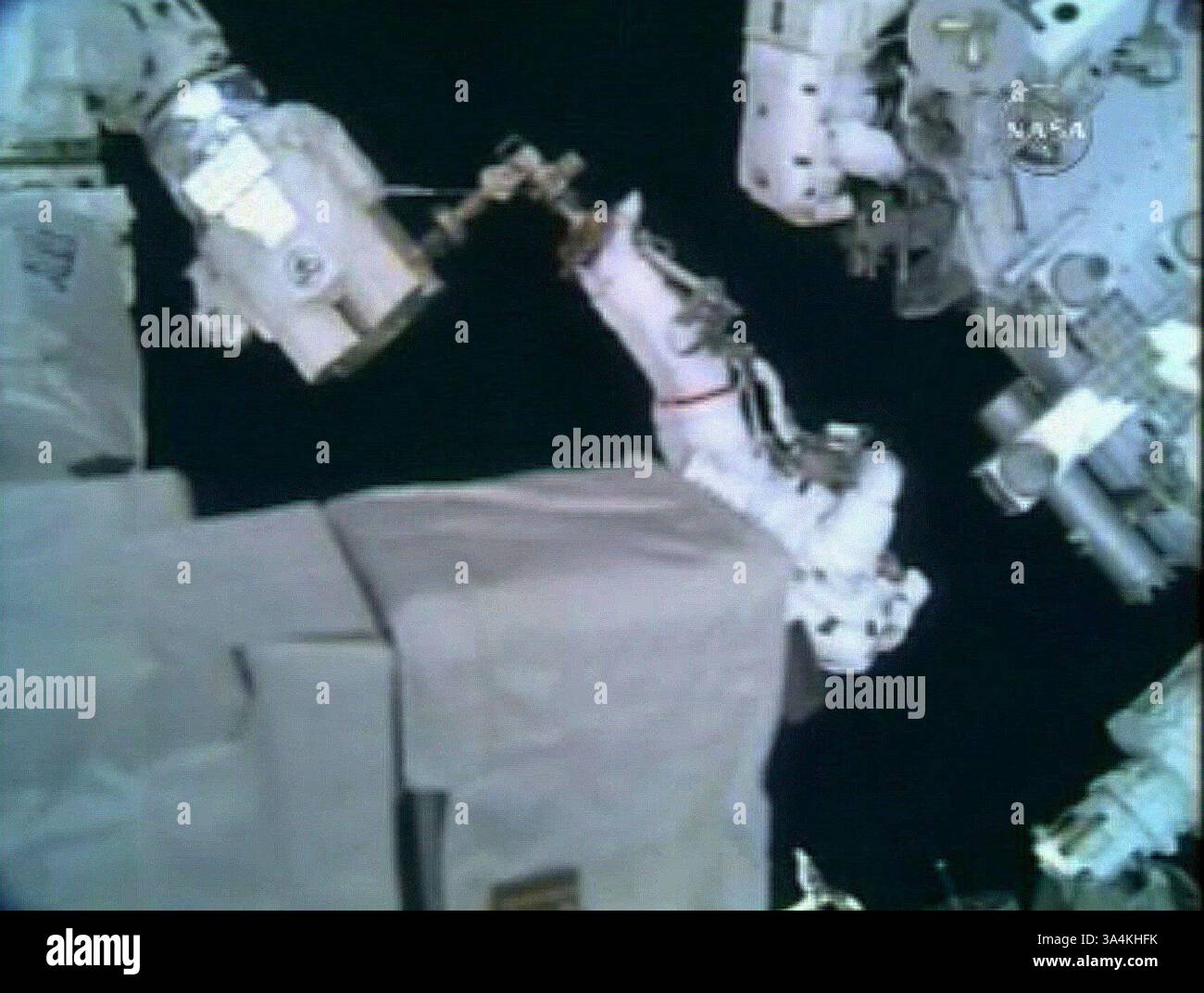 This photo made from NASA TV shows shuttle astronaut Michael Foreman, left, and astronaut ...