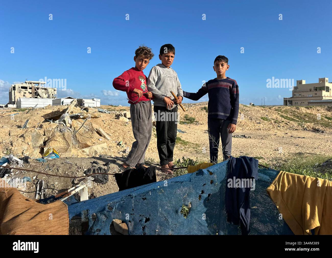 Palestinians inspect the destruction after Israeli airstrike on tents ...