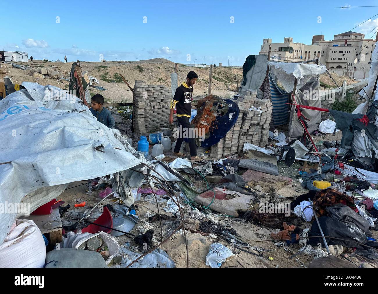 Palestinians inspect the destruction after Israeli airstrike on tents ...