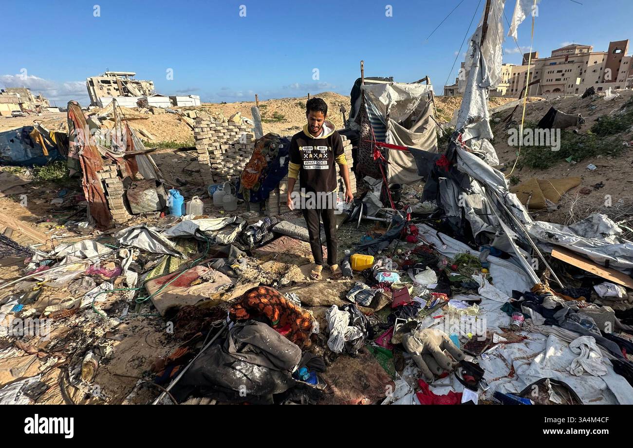 Palestinians inspect the destruction after Israeli airstrike on tents ...