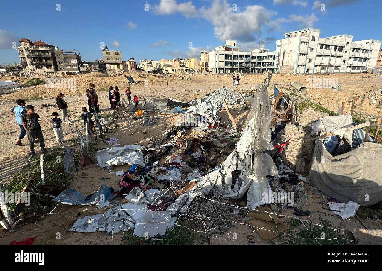 Palestinians inspect the destruction after Israeli airstrike on tents ...