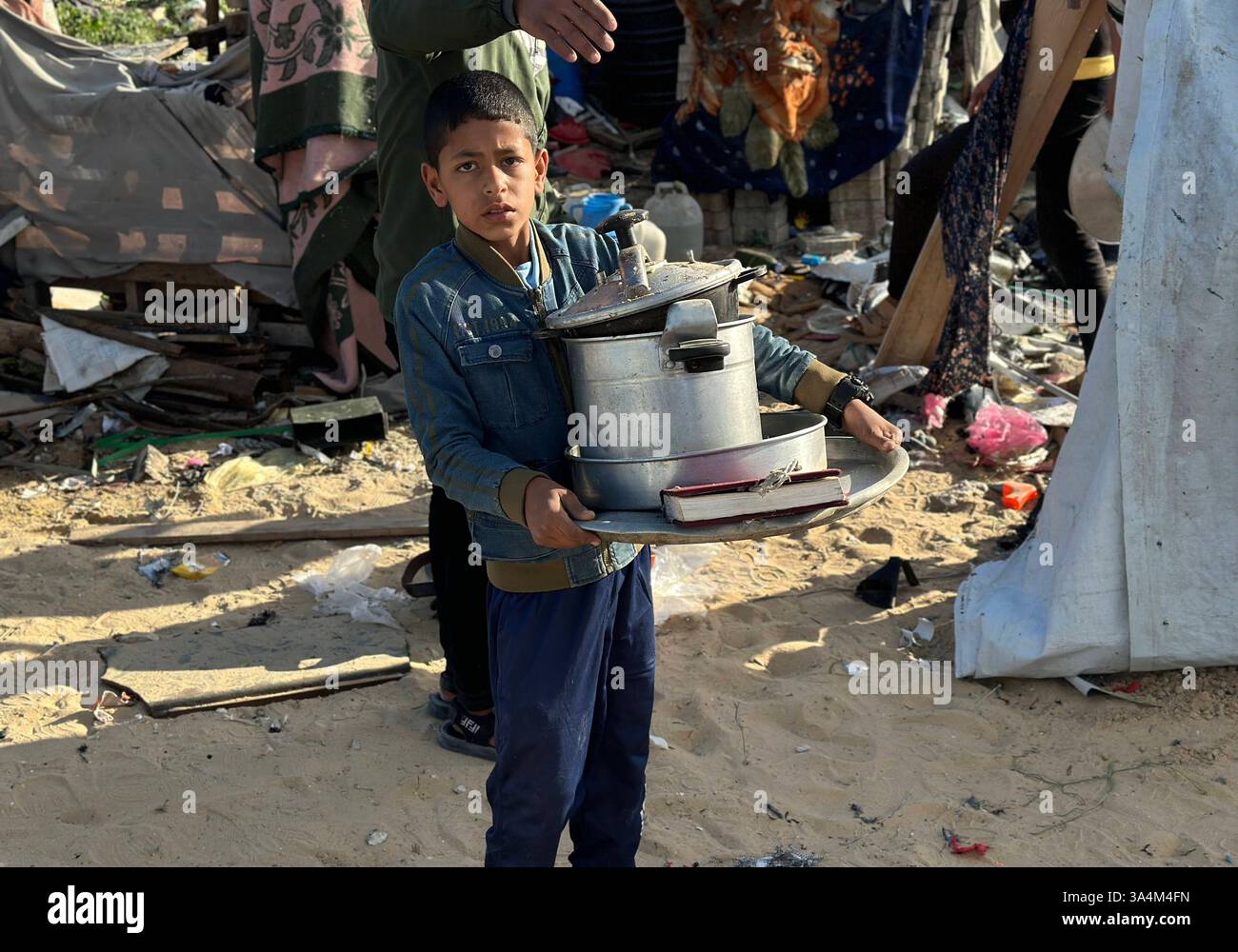 Palestinians inspect the destruction after Israeli airstrike on tents ...
