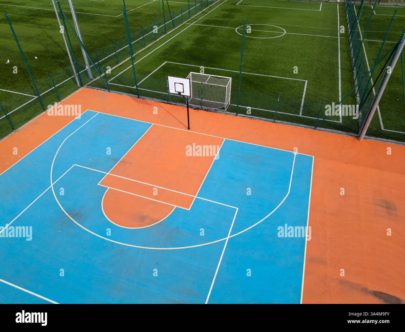 Aerial view of outdoor basketball and soccer courts with vibrant blue ...