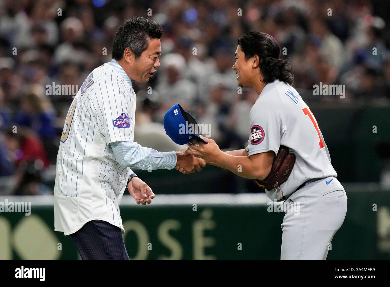 Former player Koji Uehara, left, shakes hands with Chicago Cubs' Shota Imanaga, right, after ...