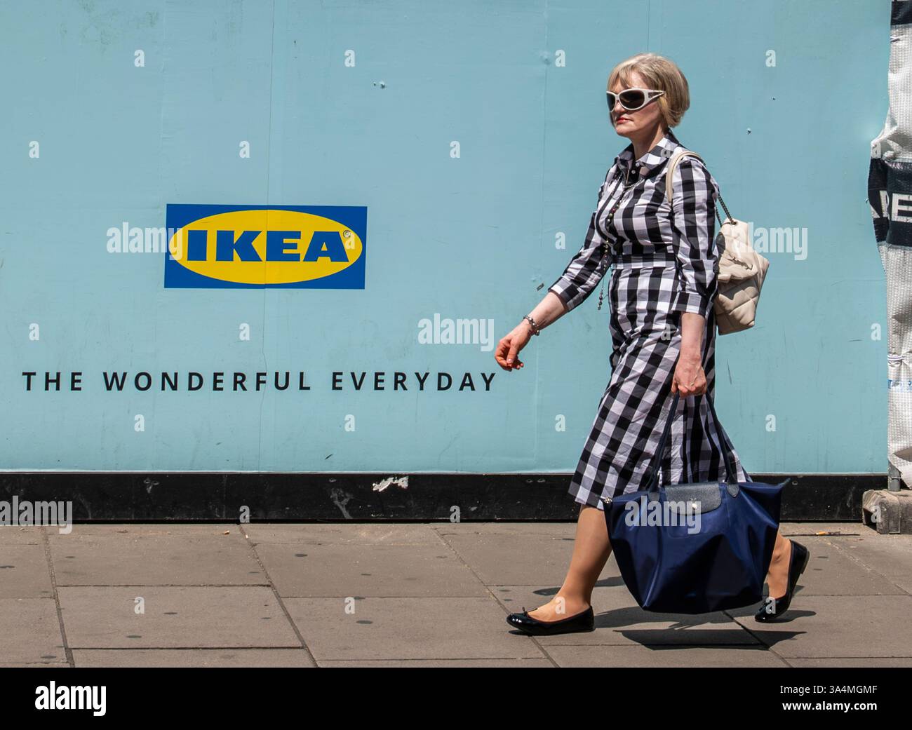A striking woman walks confidently in front of a large blue Ikea ...