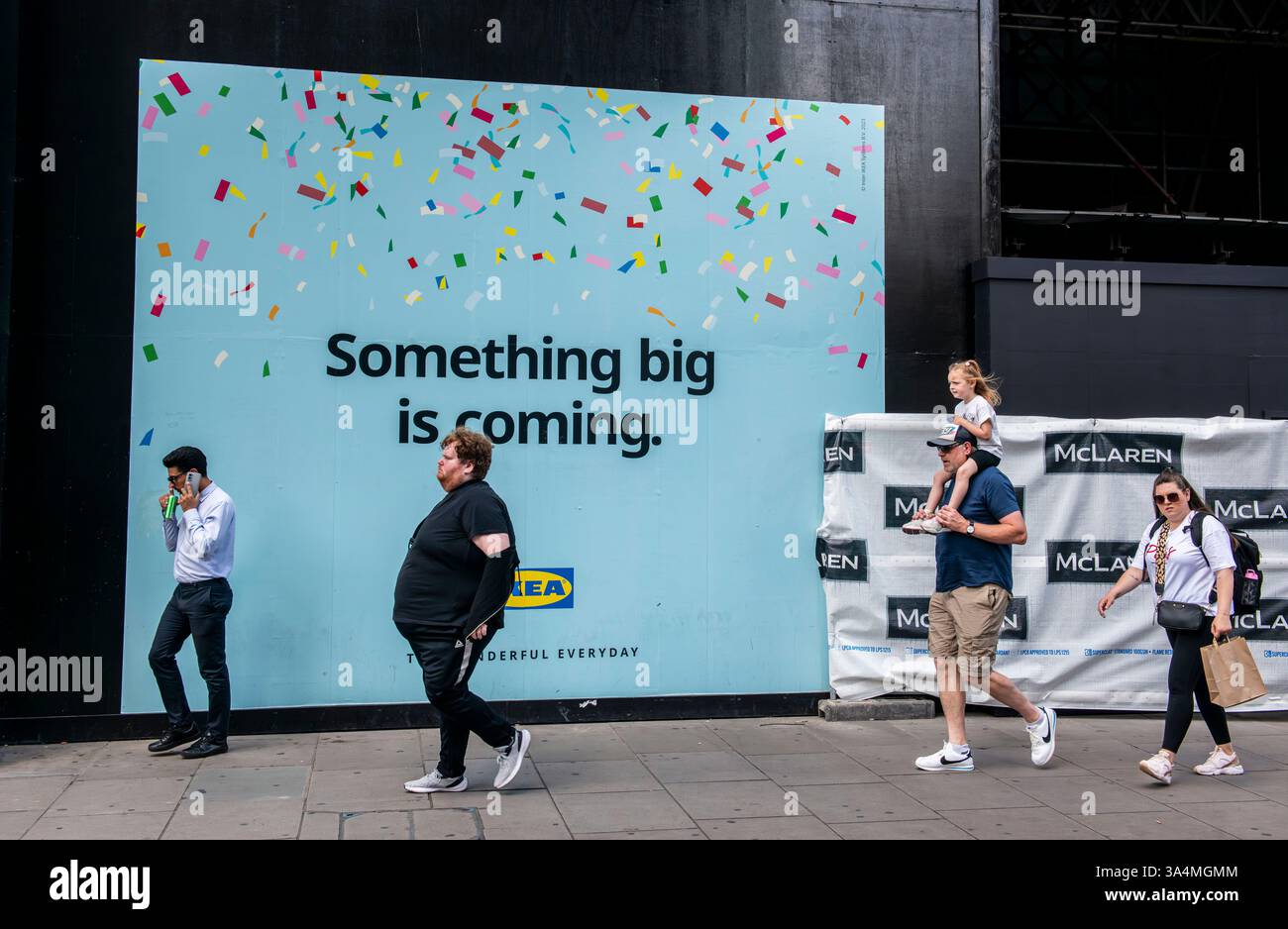 A scene unfolds in front of a large billboard saying Something Big Is ...