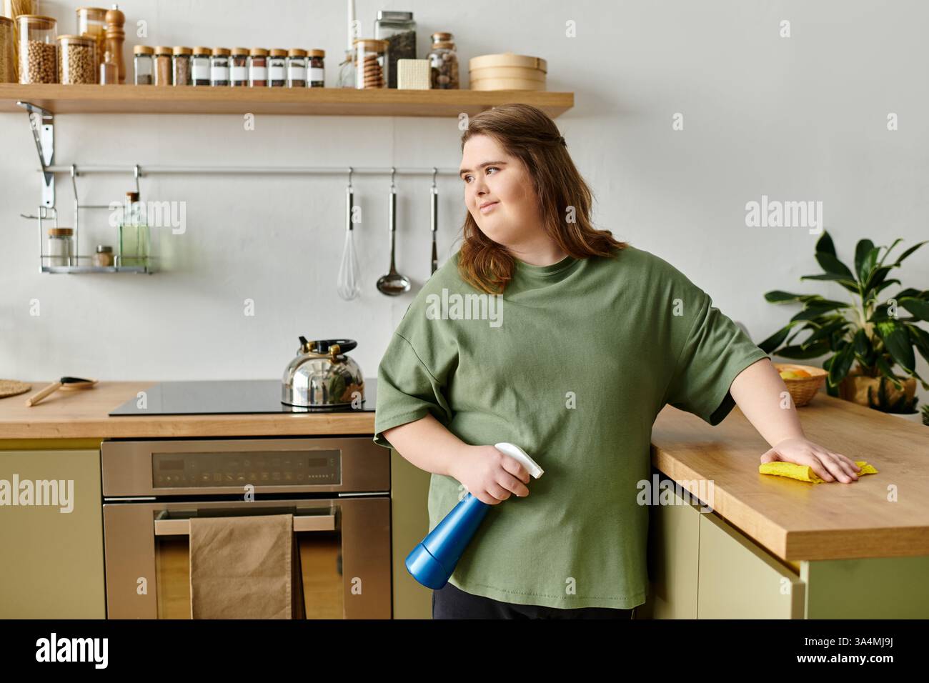 A young woman with Down syndrome stands in her inviting kitchen, ready ...