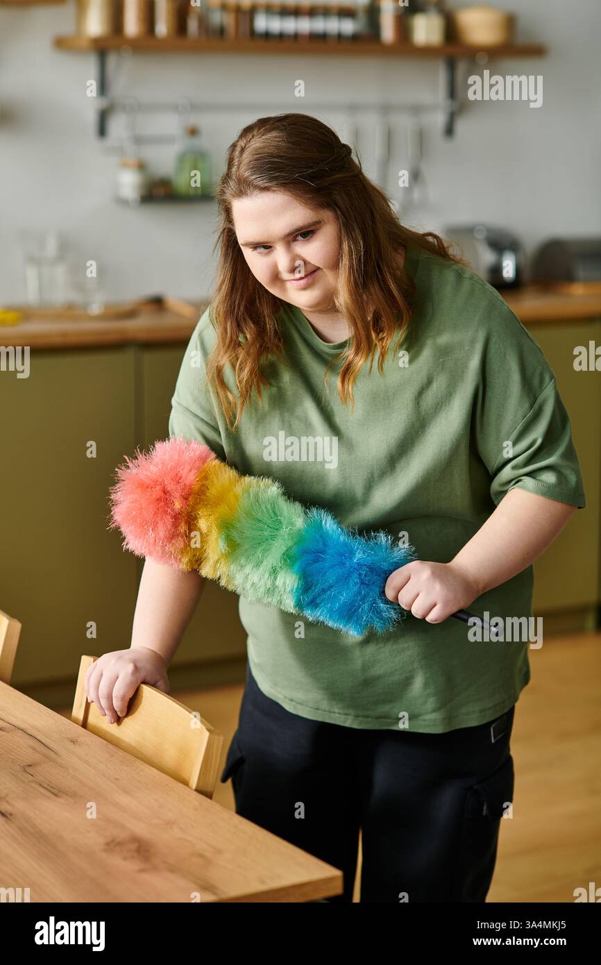 Young woman with Down syndrome enjoys cleaning at home, expressing ...