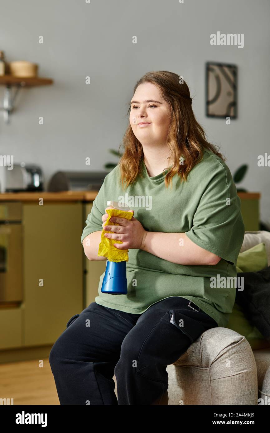 A young pretty woman with Down syndrome smiles brightly while holding ...