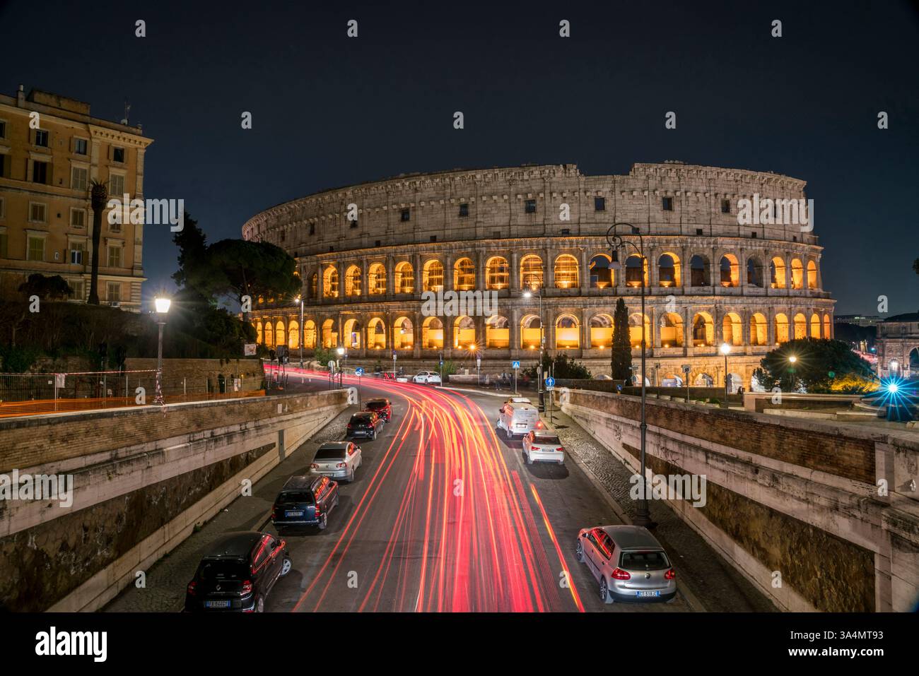 Traffic paints light trails as it speeds past the Colosseum in Rome in ...