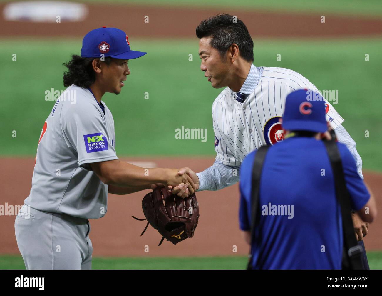 Koji Uehara, Japanese former professional baseball pitcher, shakes hands with Shota Imanaga of ...