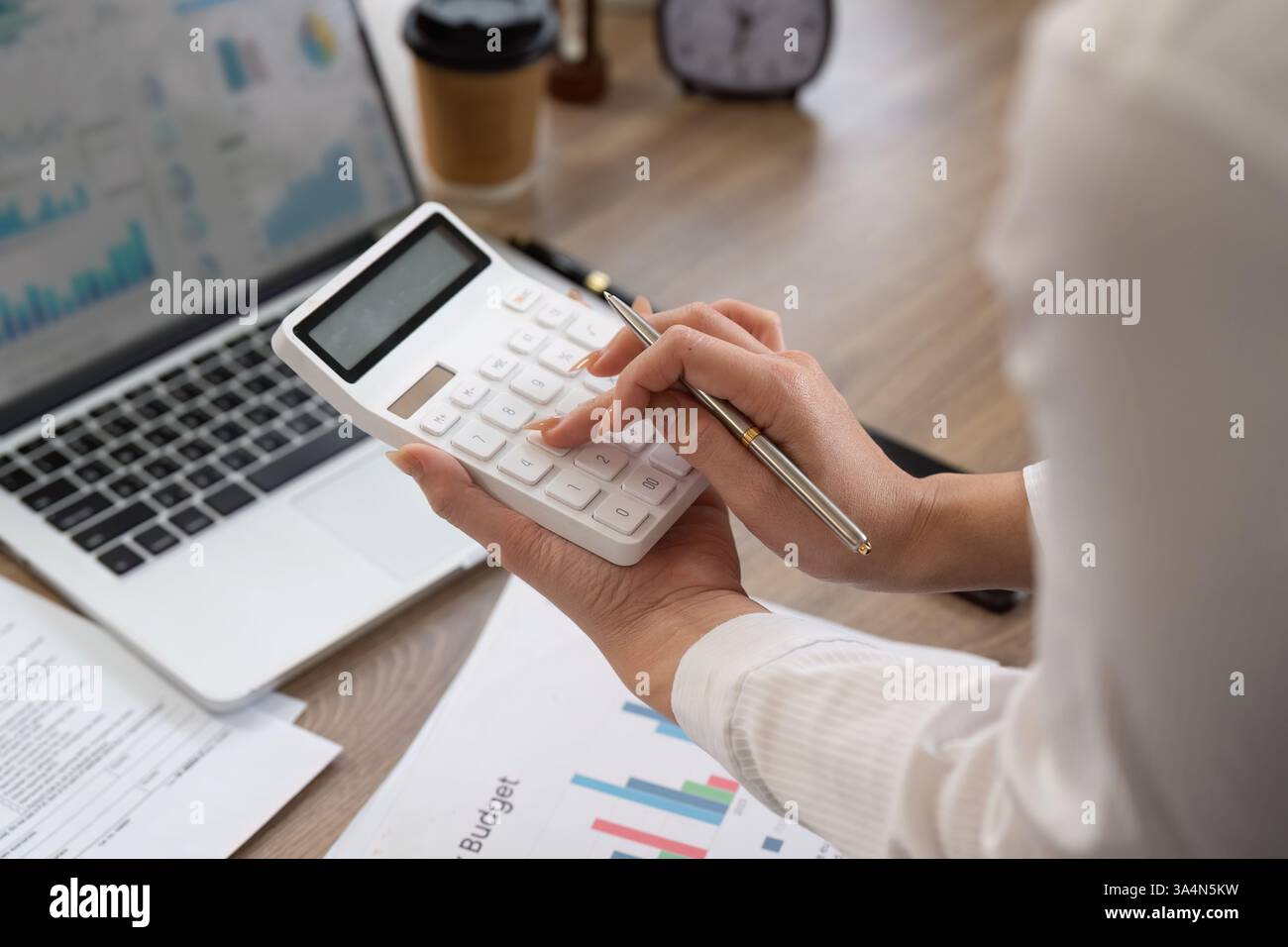 Focused professional using calculator for financial analysis and ...