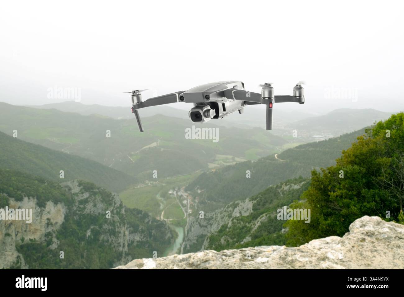 Drone with camera flying in mountains. Unmanned aerial vehicle for ...