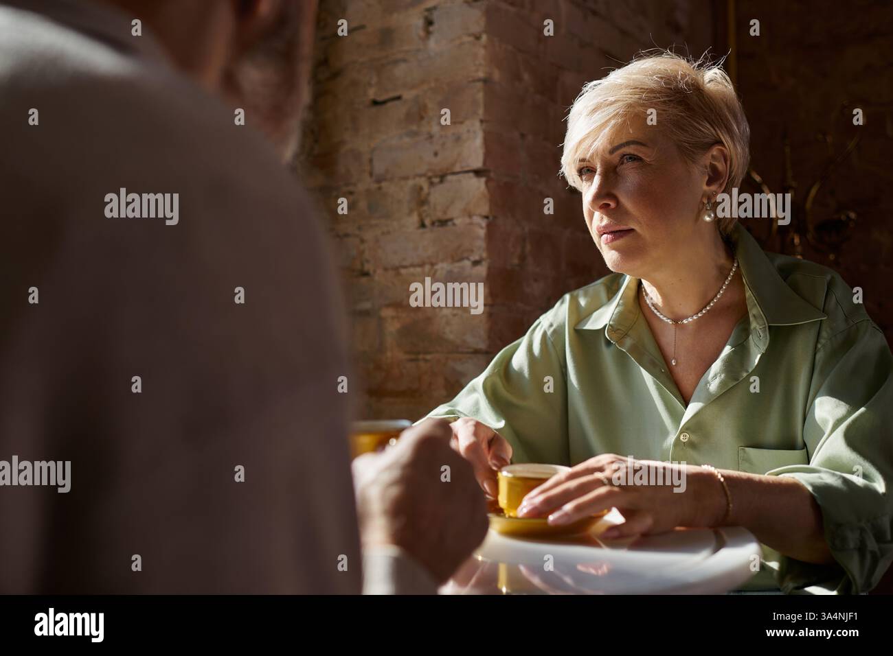 A middle aged couple enjoys a romantic date, engaging in deep ...