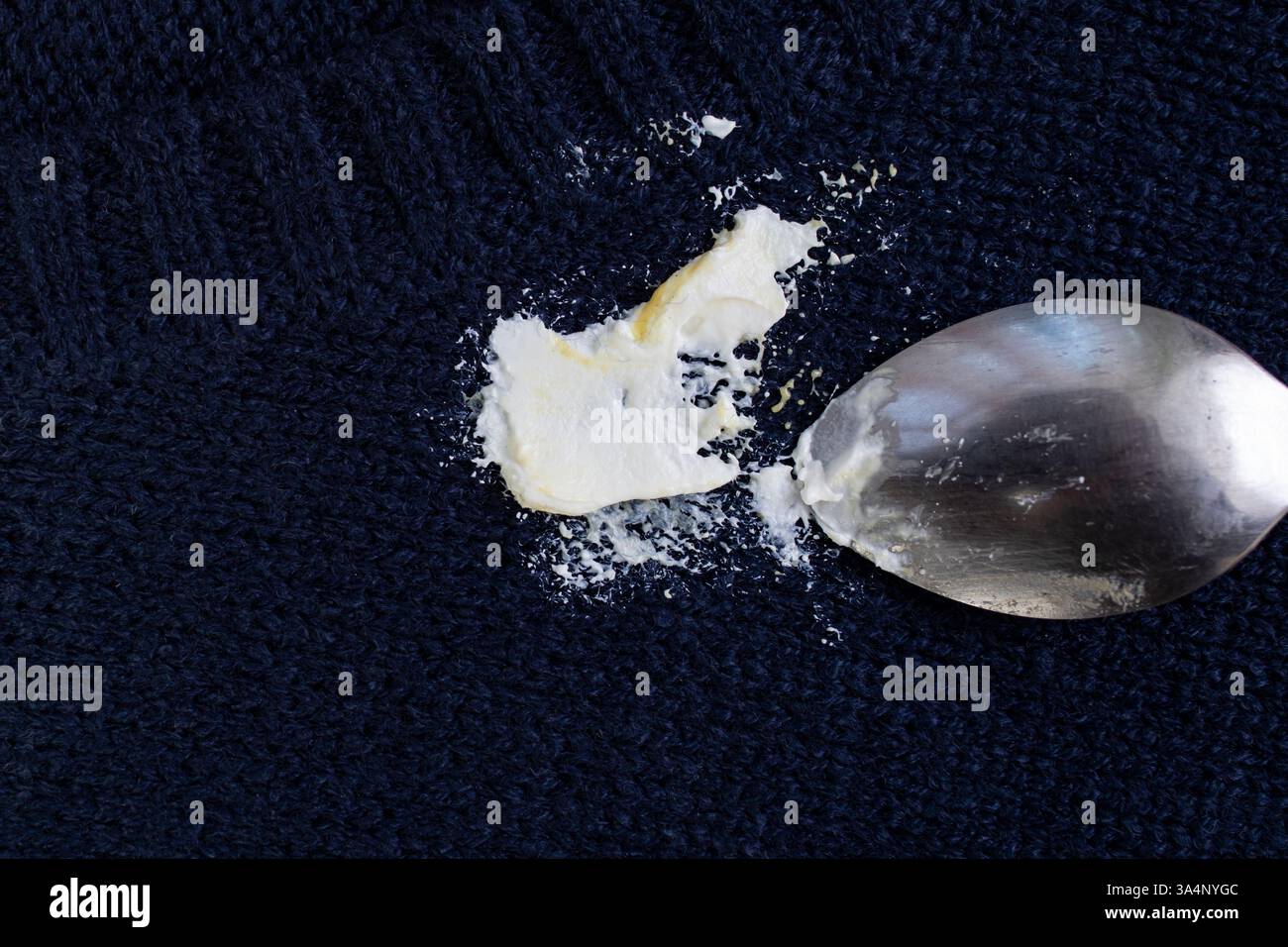 Pullover woven fabric with a white yogurt stain and silver tea spoon ...