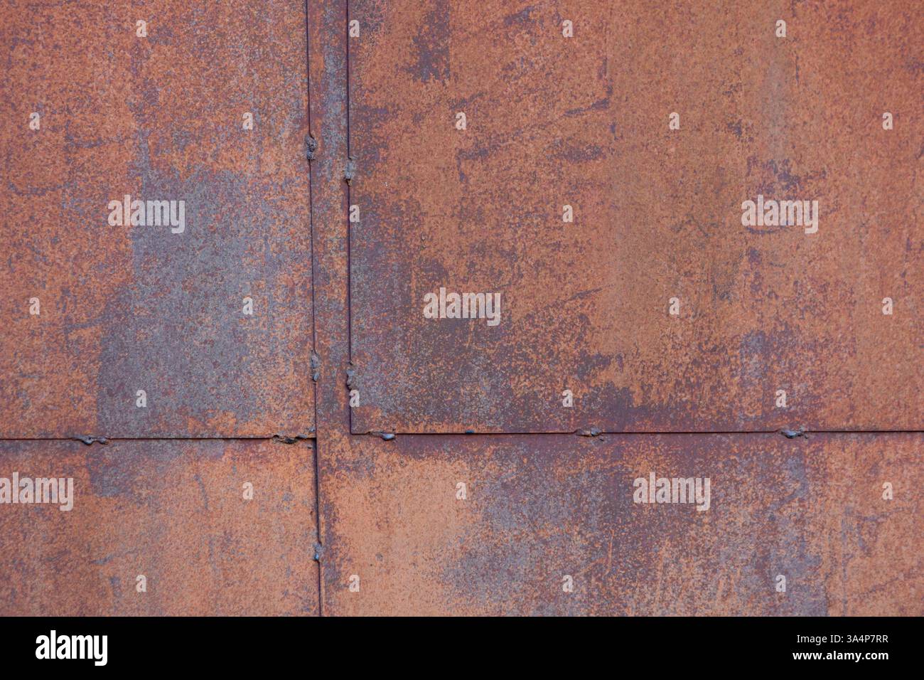A textured metal surface covered with tin sheets, showing patches of ...