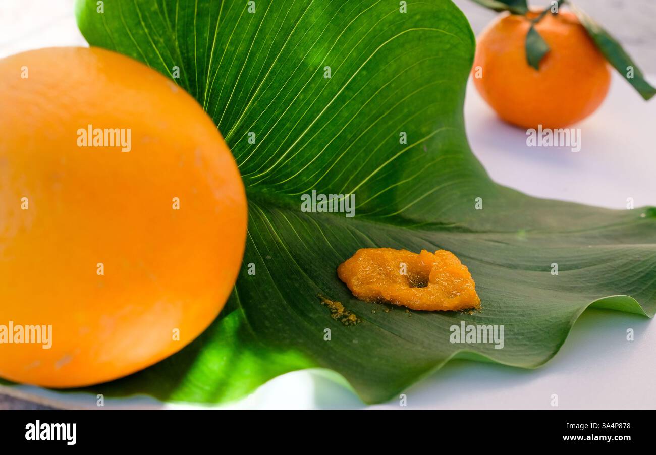 Smear of citrus body scrub on bright green leaf background. Orange ...