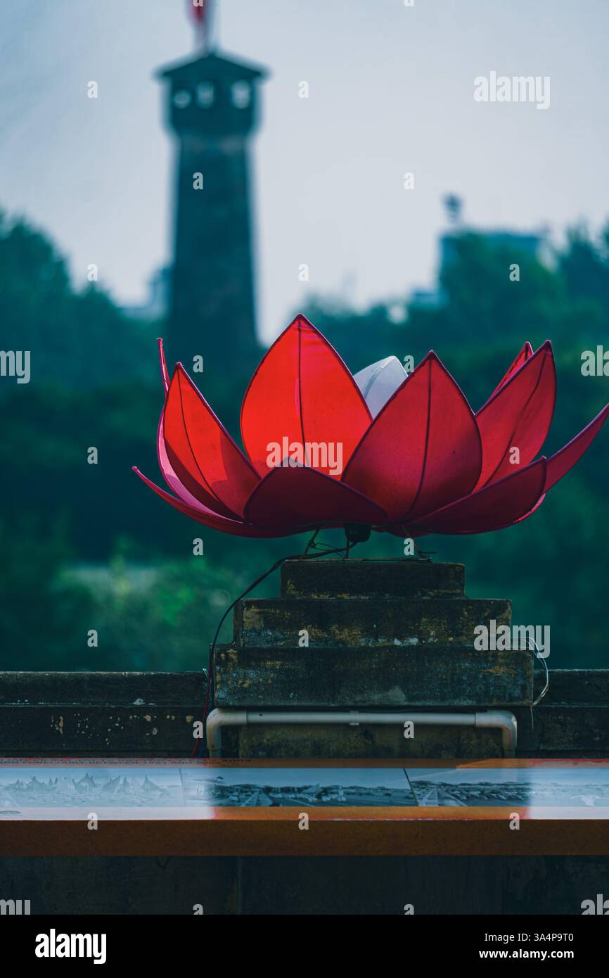 Close-up of a decorative lotus flower light with the Hanoi Flag Tower ...