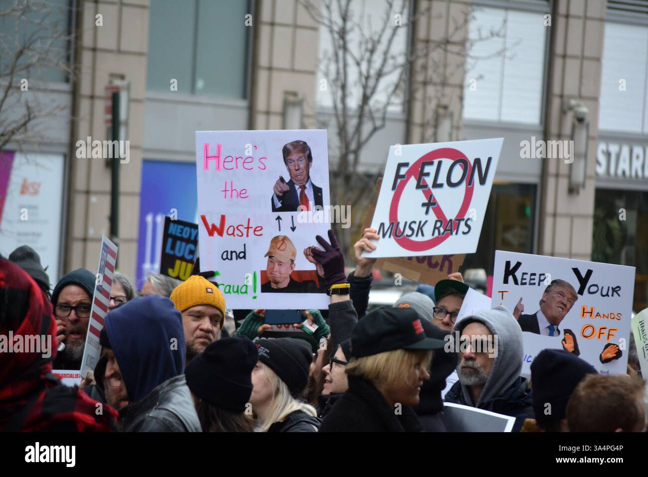 People marching with signs at a Stop the Cuts rally against DOGE in ...